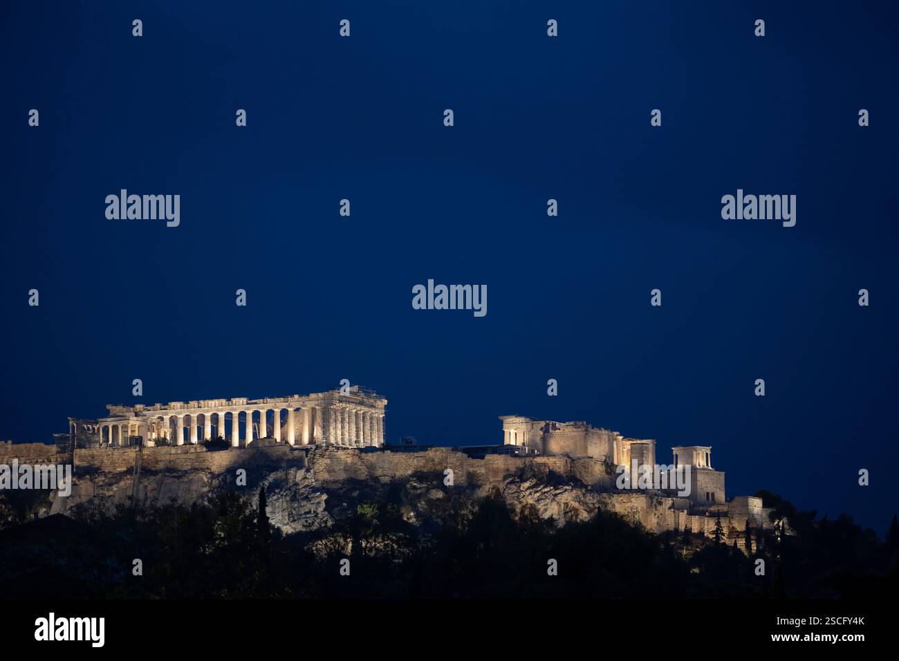 Acropolis lighted at night at the blue hour from down in the city of ...