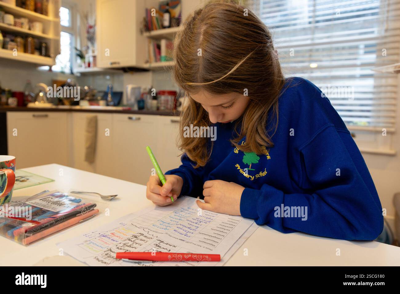 A nine year old school girl practises her spelling homework on the ...