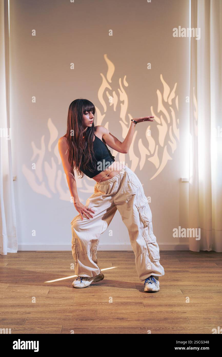 Model performing a dance pose in a stylish studio with unique shadow ...