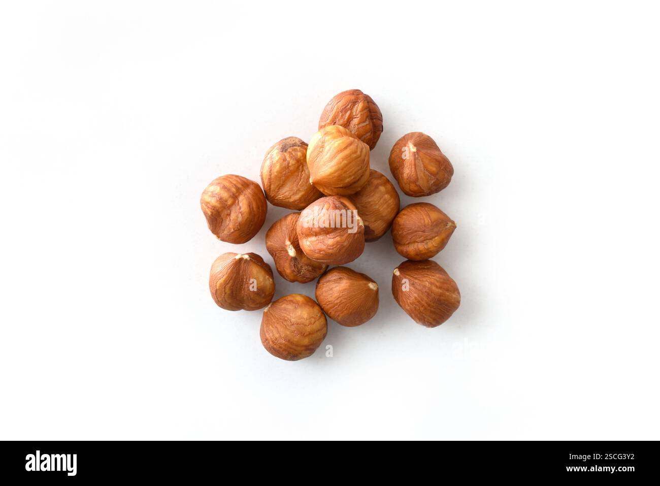 Background detail of heap of shelled hazelnuts isolated on white table ...