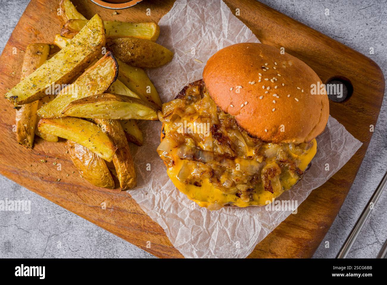 Smash burger with cheddar cheese and caramelized onions, served with ...