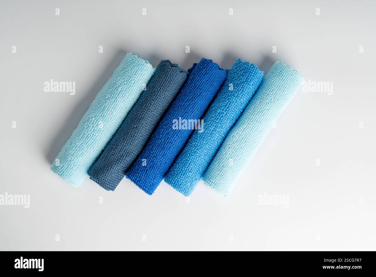 Colorful microfiber towels on a white table. Cleaning and housekeeping ...