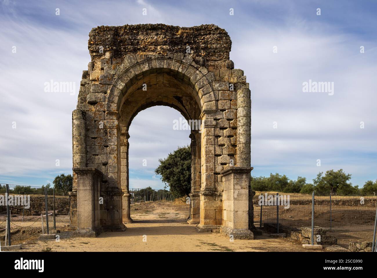 Ancient Roman arch in the ruins of Caparra, Spain, surrounded by a ...