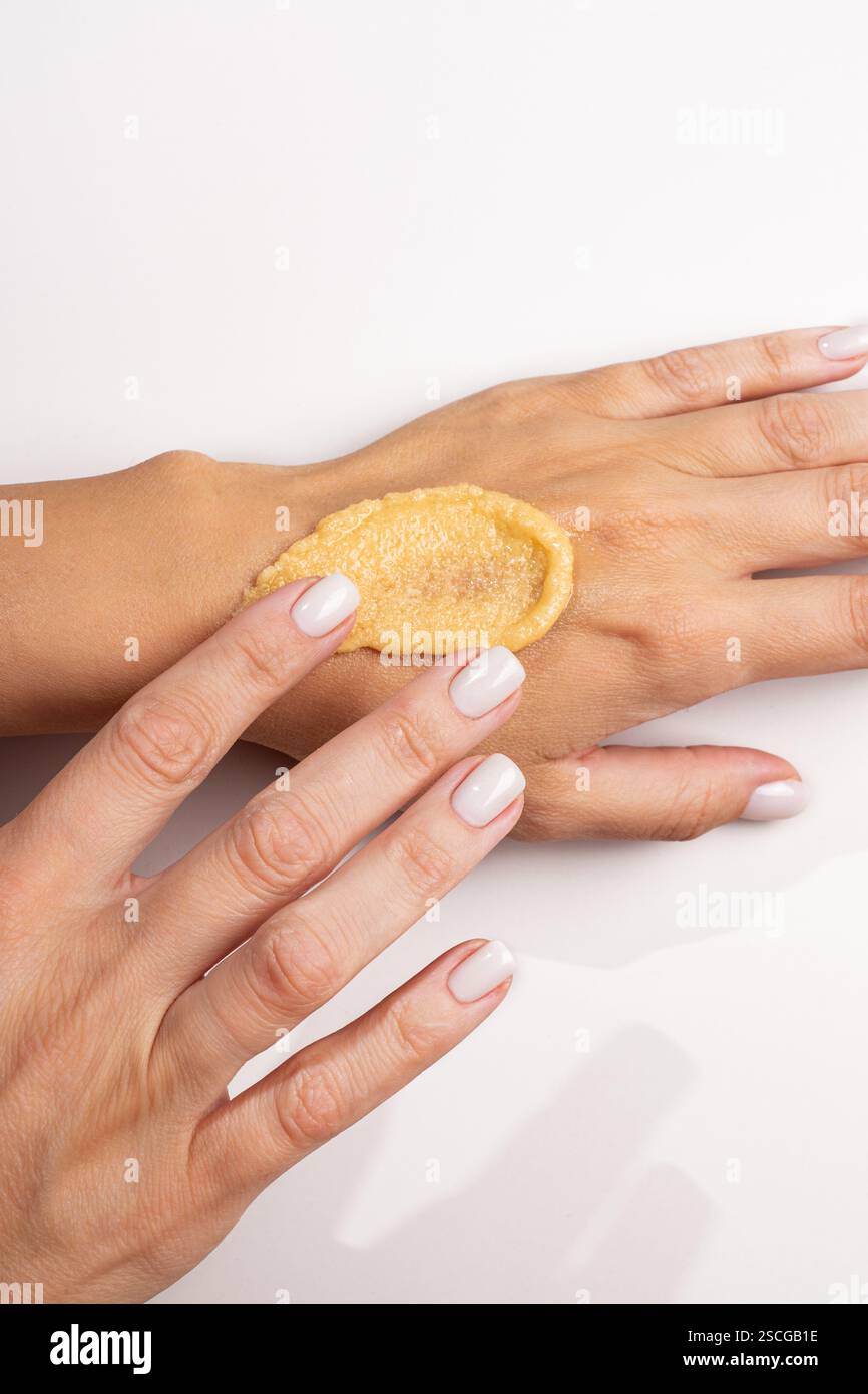Yellow scrub swatch smudge smear on woman's hand, textured scrub Stock ...