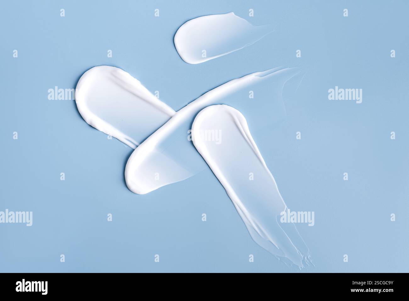 White smudges swatches smear of face or body care cream on a blue ...