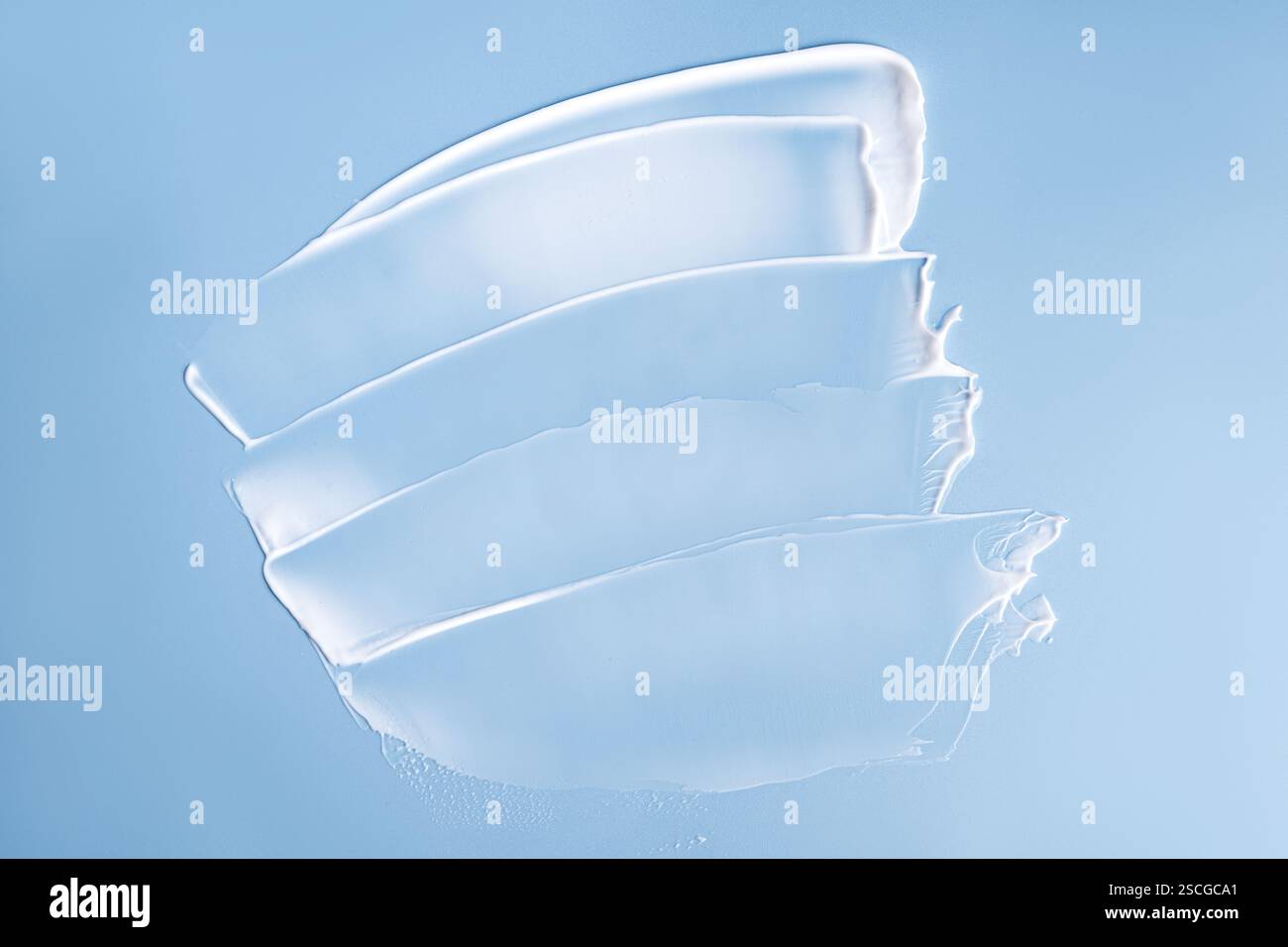 White smudges swatches smear of face or body care cream on a blue ...