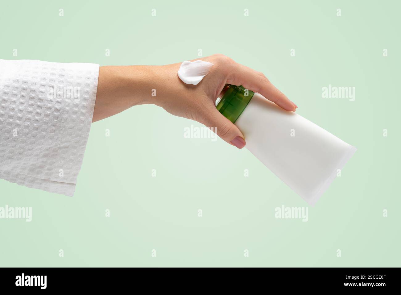 A white smear of body smoothing cream on woman's hand, hand holding ...