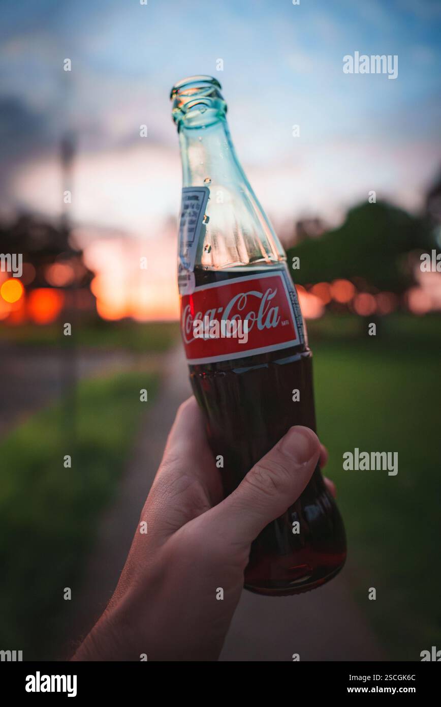 Hand Holding Glass Coca Cola Bottle Against Vibrant Sunset Sky Stock ...