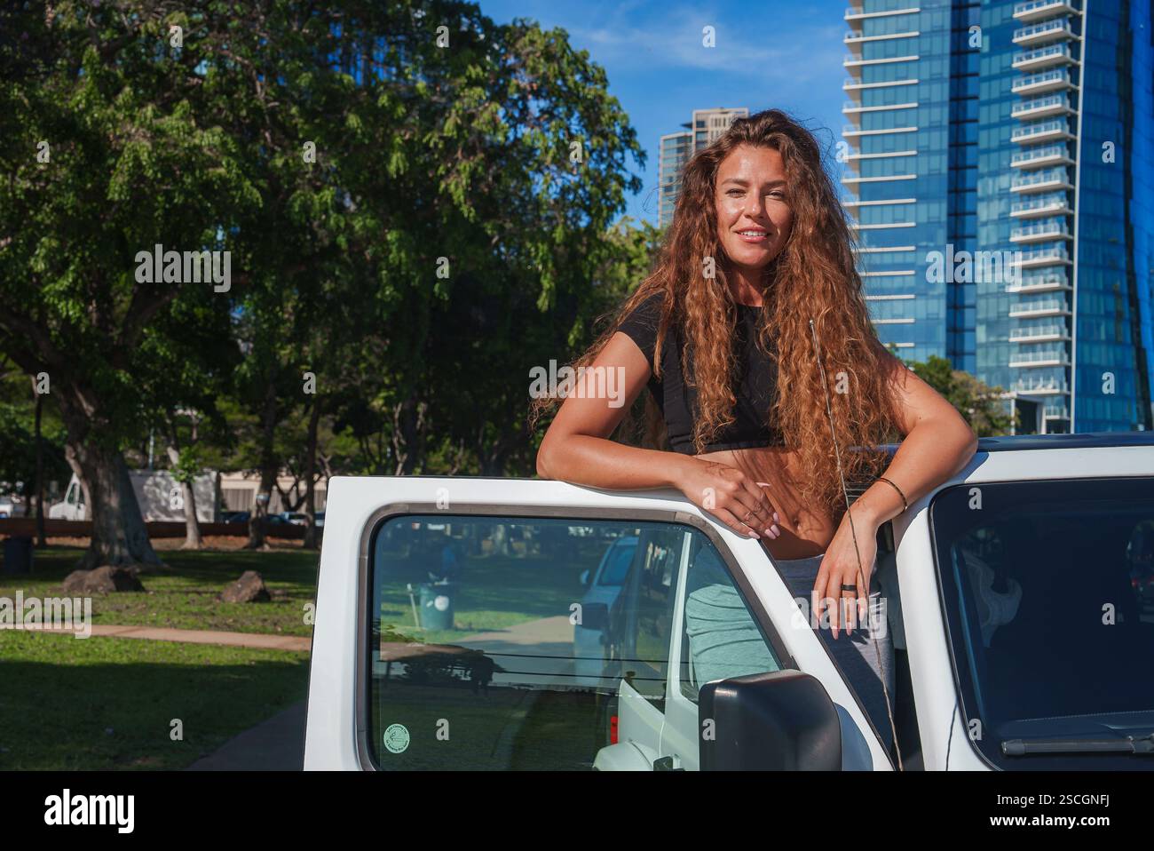 Woman Leaning on White Vehicle in Urban Honolulu Setting Stock Photo ...