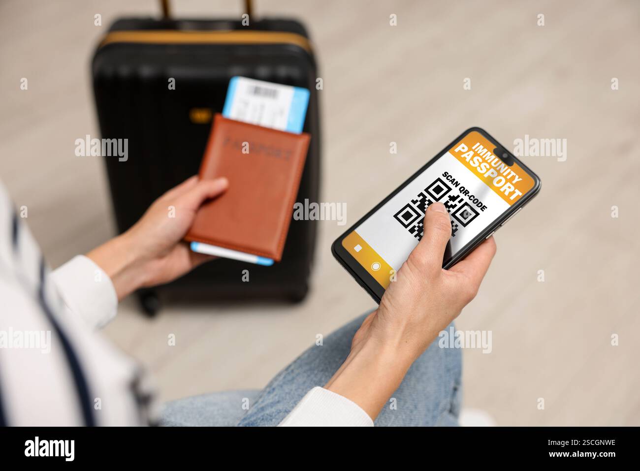 Tourist with passport, flight ticket and mobile phone indoors, above ...