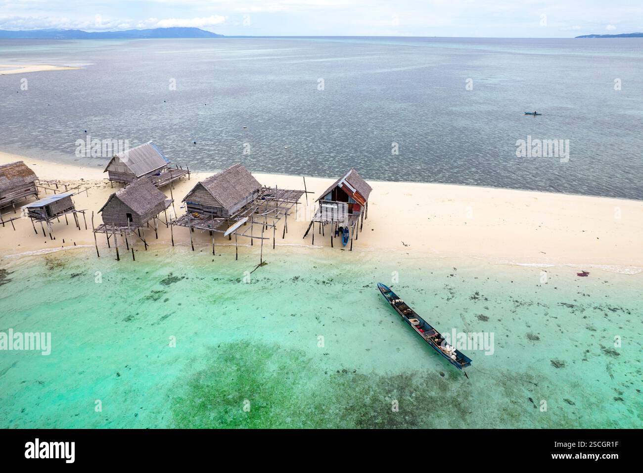 Village of bajau laut people on a small sandy tropical island, sandbank ...