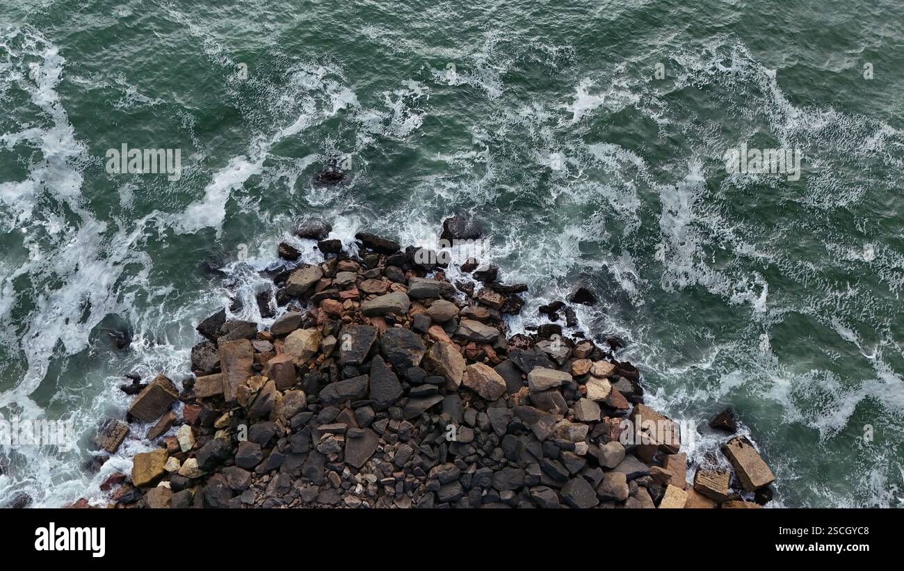 Aerial top view of sea waves hitting rocks on the beach in Swakopmund ...