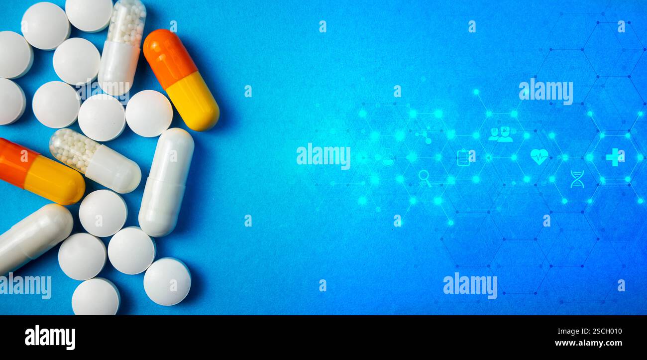 Different shapes and colors of capsules and tablets are spread across a ...