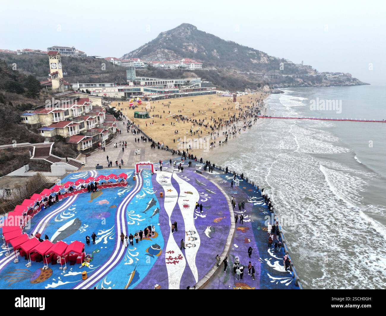 Aerial photo shows tourists playing at the seaside in Lianyungang City ...