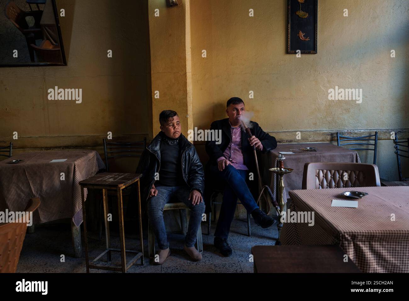 A man and his son sit inside a local coffe shop in the northeastern ...