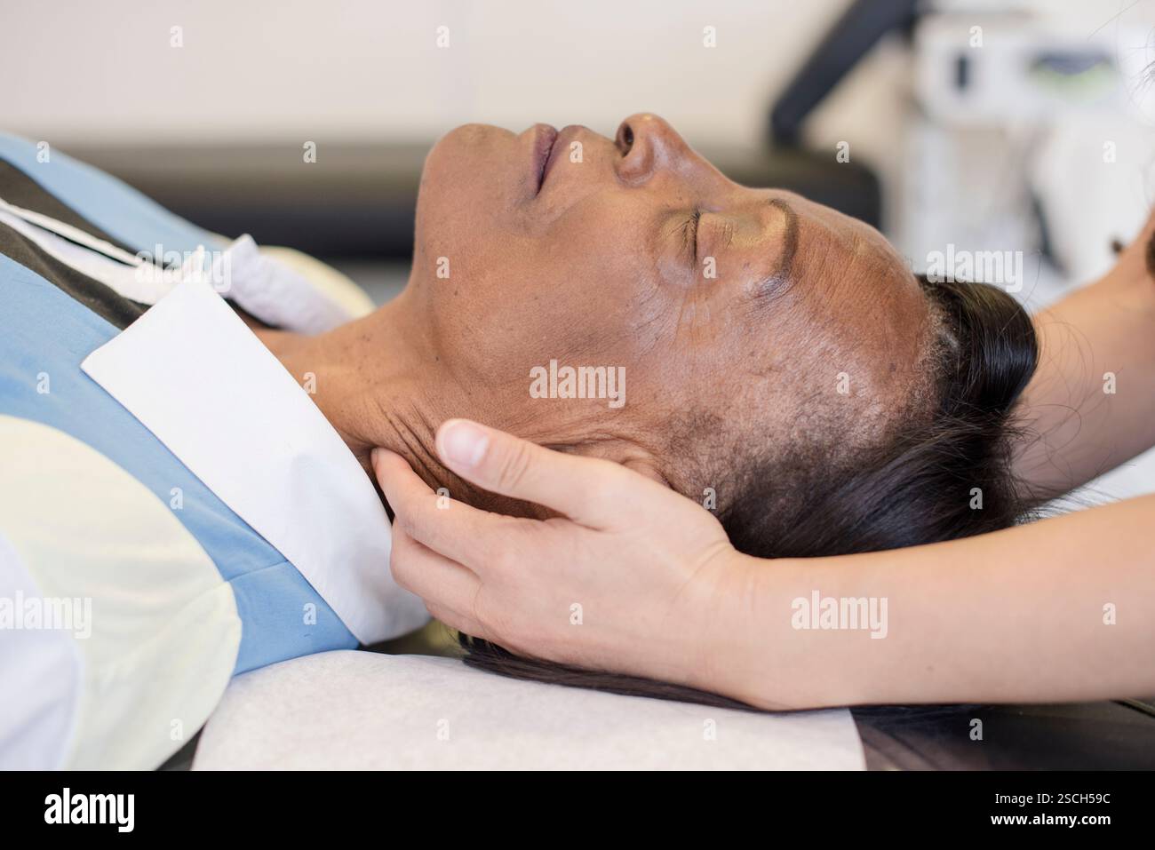 Doctor adjusting patients neck while laying down Stock Photo - Alamy