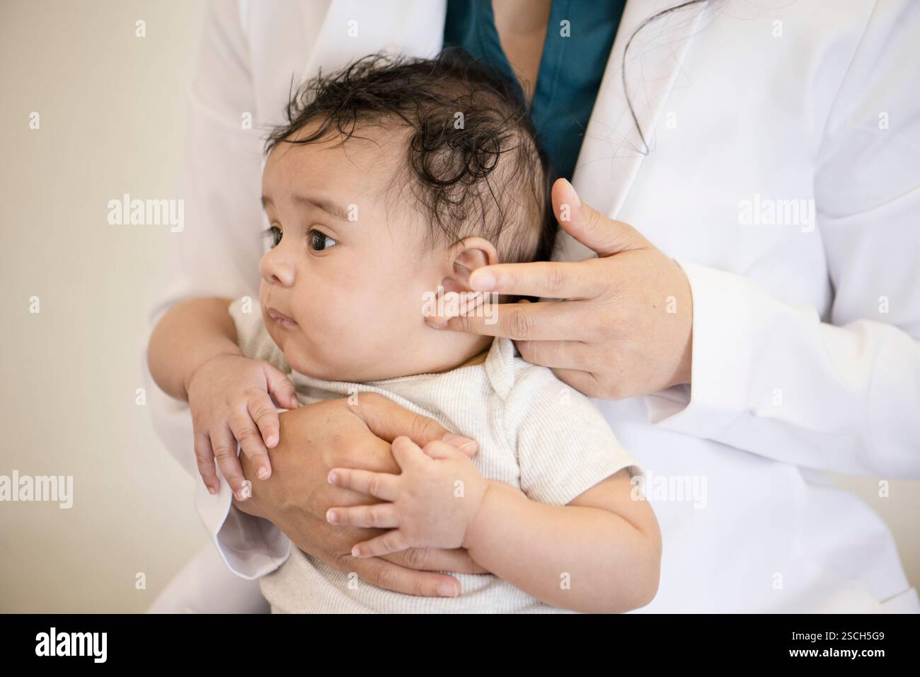 Female doctor checking baby boy in clinic Stock Photo - Alamy