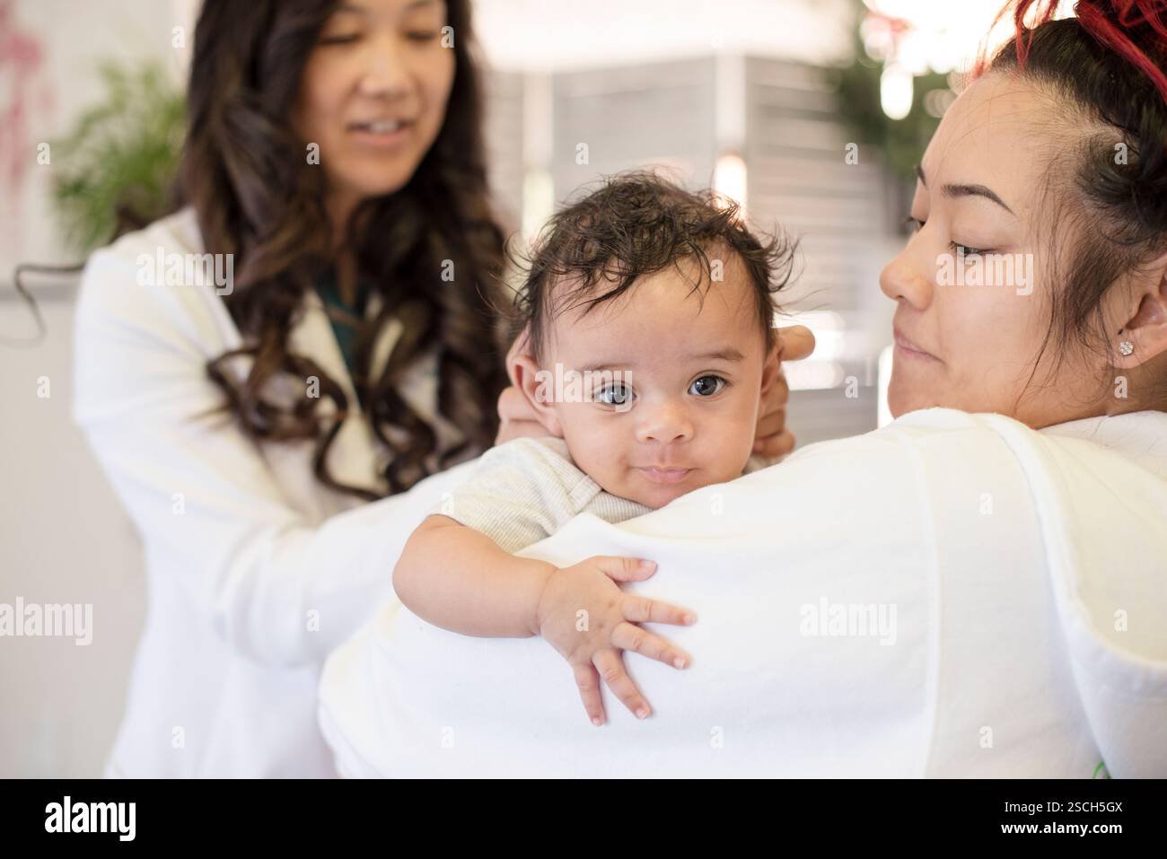 Parent holding baby while doctor evaluates baby Stock Photo - Alamy