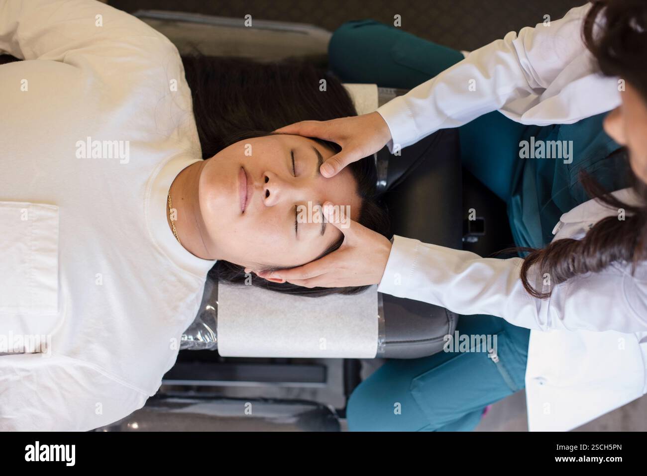 Doctor doing a cranial adjustment on patient Stock Photo - Alamy