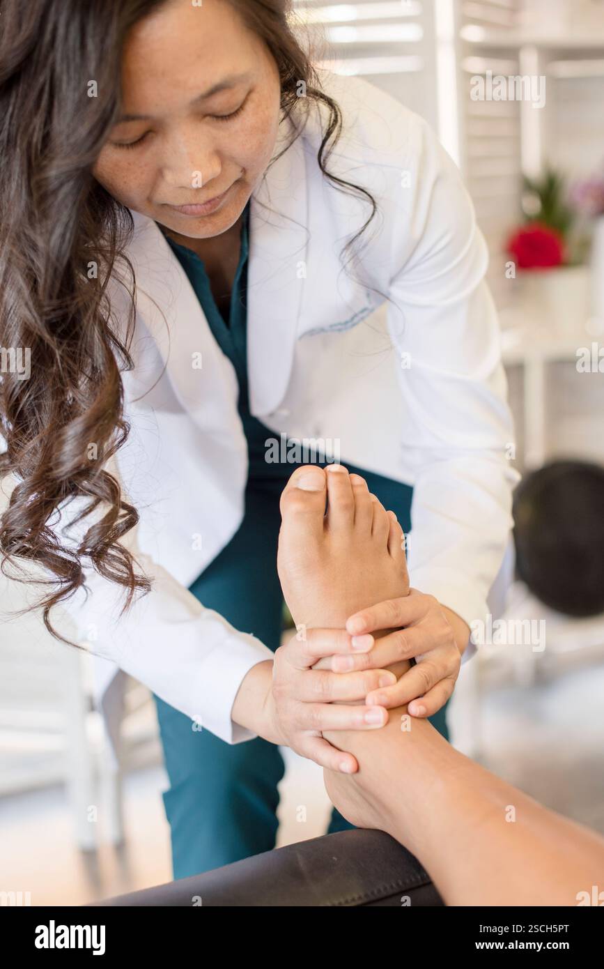 Doctor looking at patients foot Stock Photo - Alamy