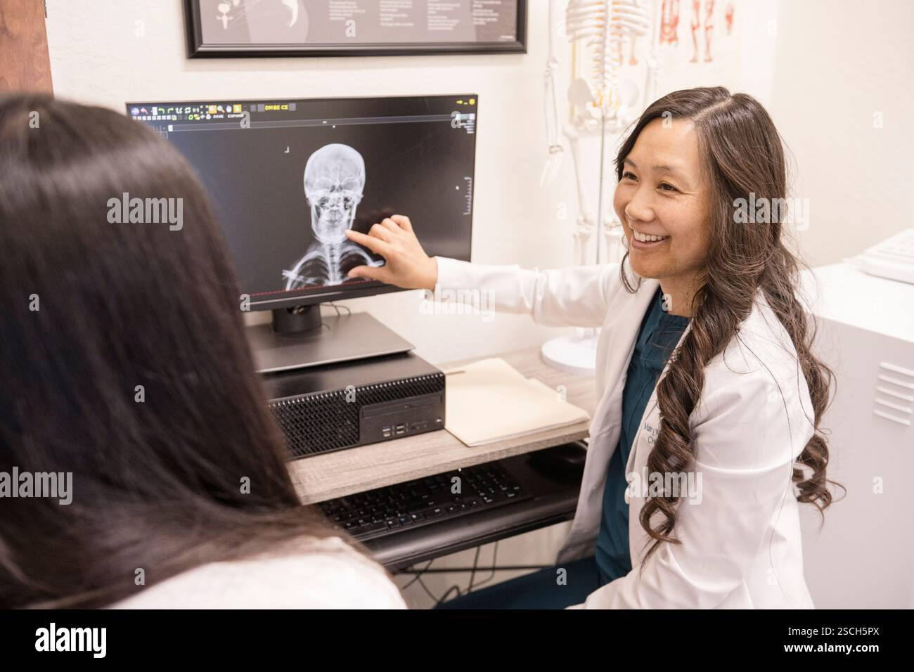 Doctor showing patient x-ray of skull on computer Stock Photo - Alamy