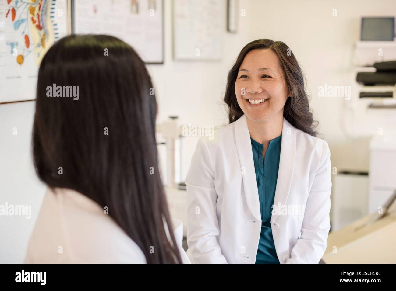 Doctor smiling at patient in doctors office Stock Photo - Alamy