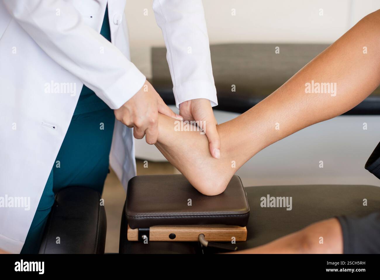 Doctor evaluating a patients ankle and foot Stock Photo - Alamy