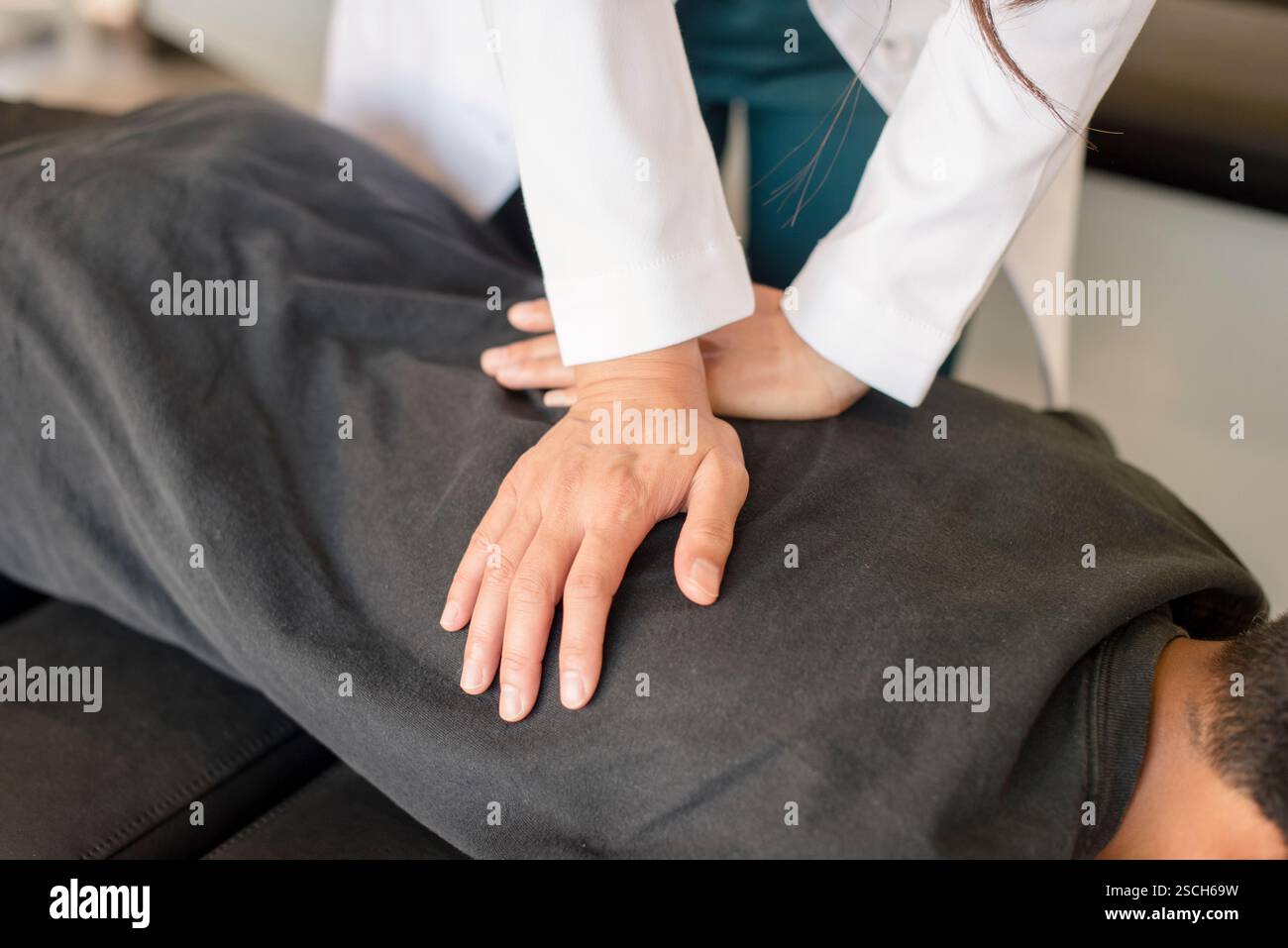 Doctor adjusting young patients back Stock Photo - Alamy