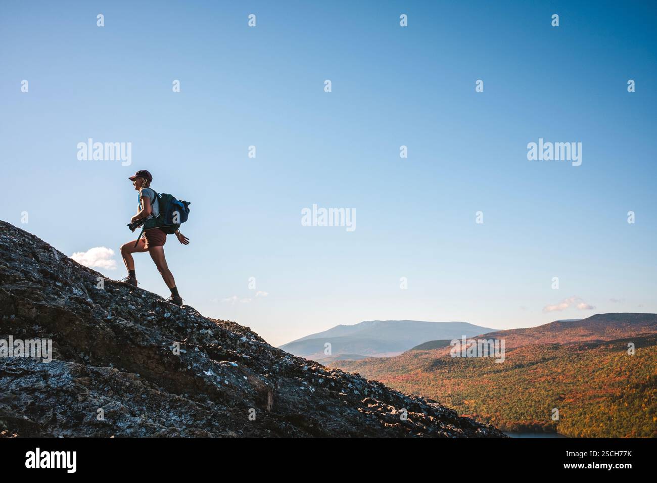 woman hikes steep mountain in Maine during fall foliage Stock Photo - Alamy