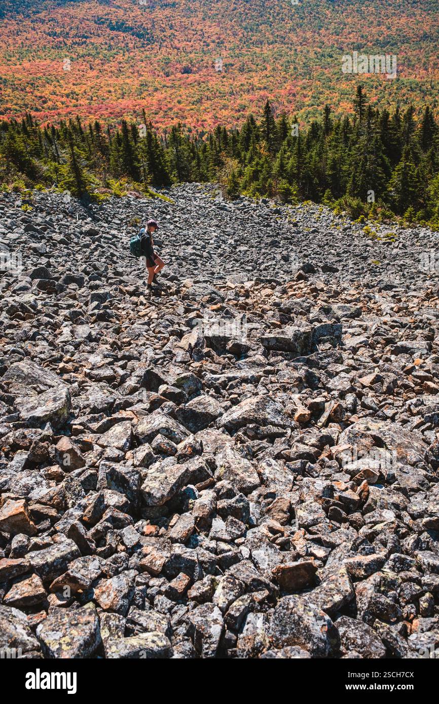 Woman hikes across rock slide during fall foliage season, Maine Stock ...
