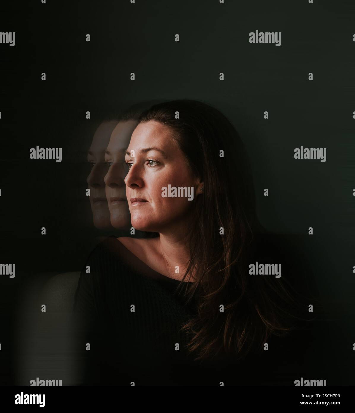 Repeating fading portrait of woman with long brown hair in dark room ...