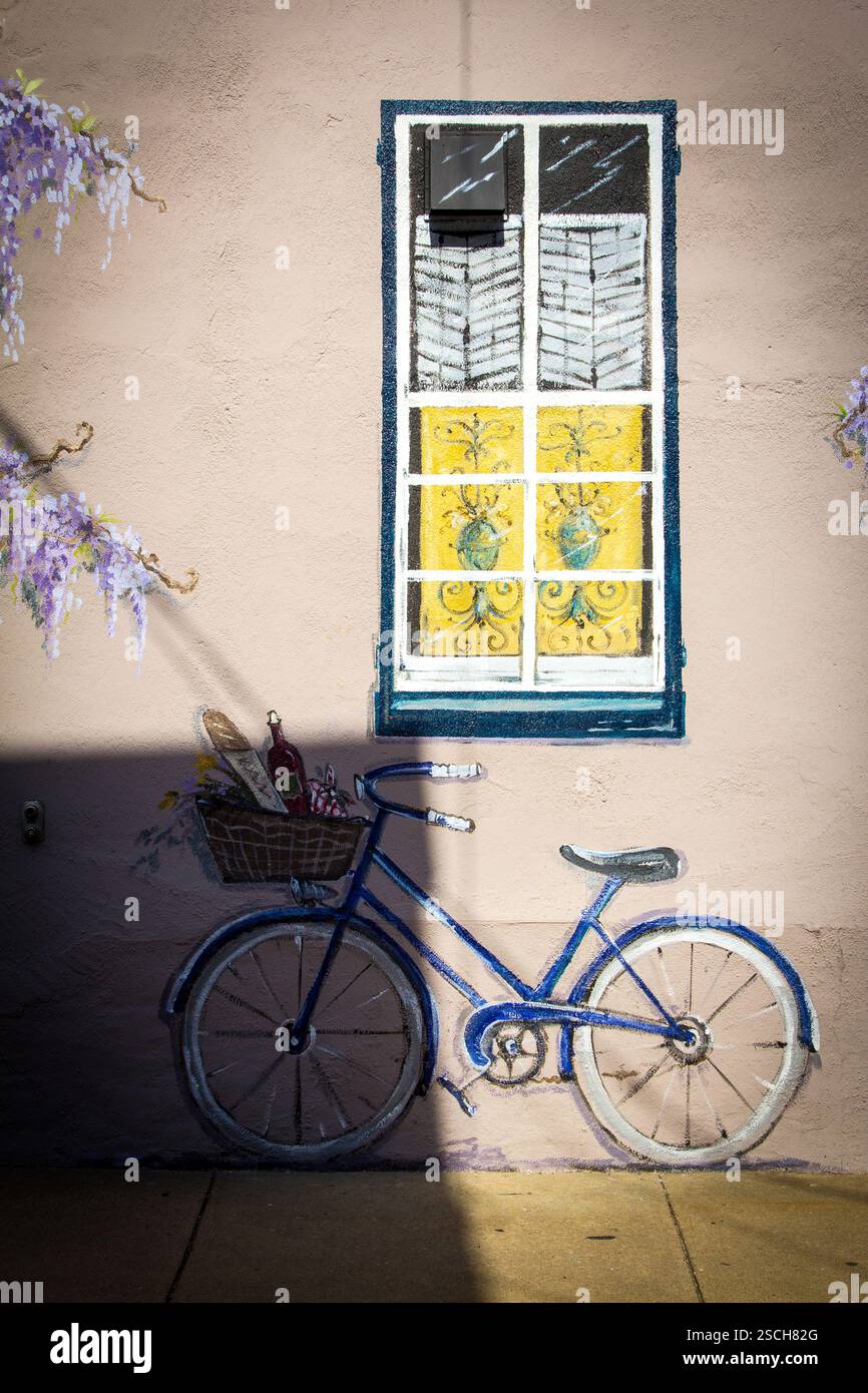 Mural depicts a bike, window, & wisteria. Art on a wall Stock Photo - Alamy