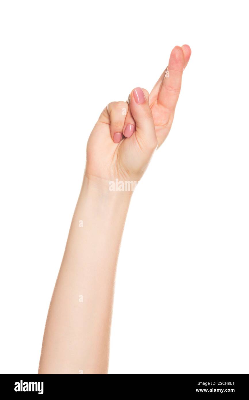Hand gesture depicting crossed fingers for good luck, against a plain ...