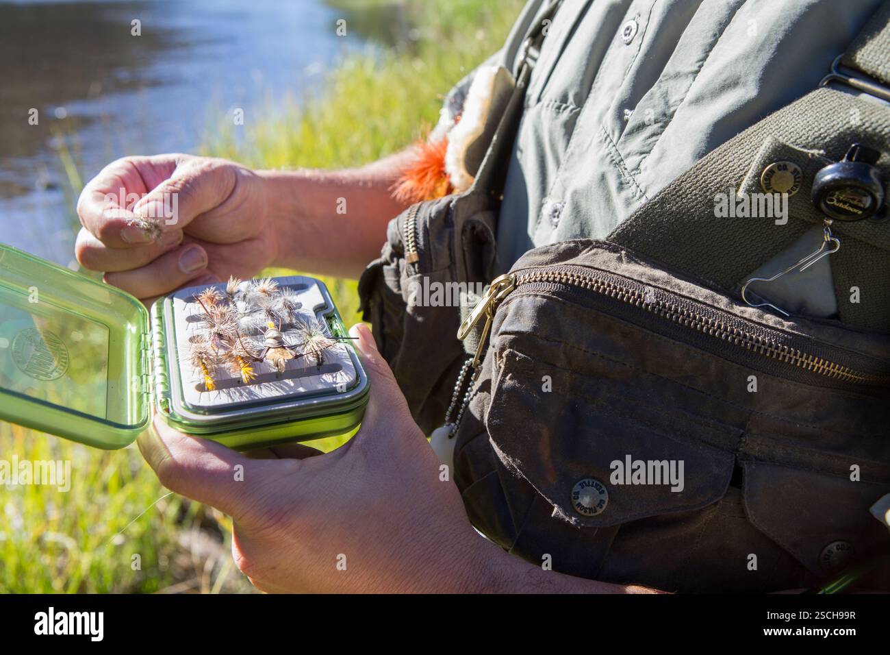 Fly Fisherman chooses his favorite fly Stock Photo - Alamy
