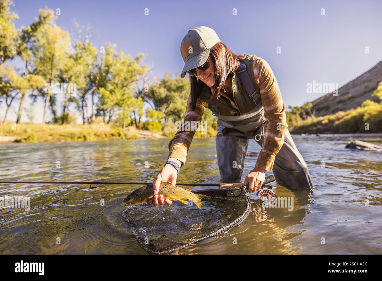Fly fishing woman show off a brown trout2 Stock Photo - Alamy