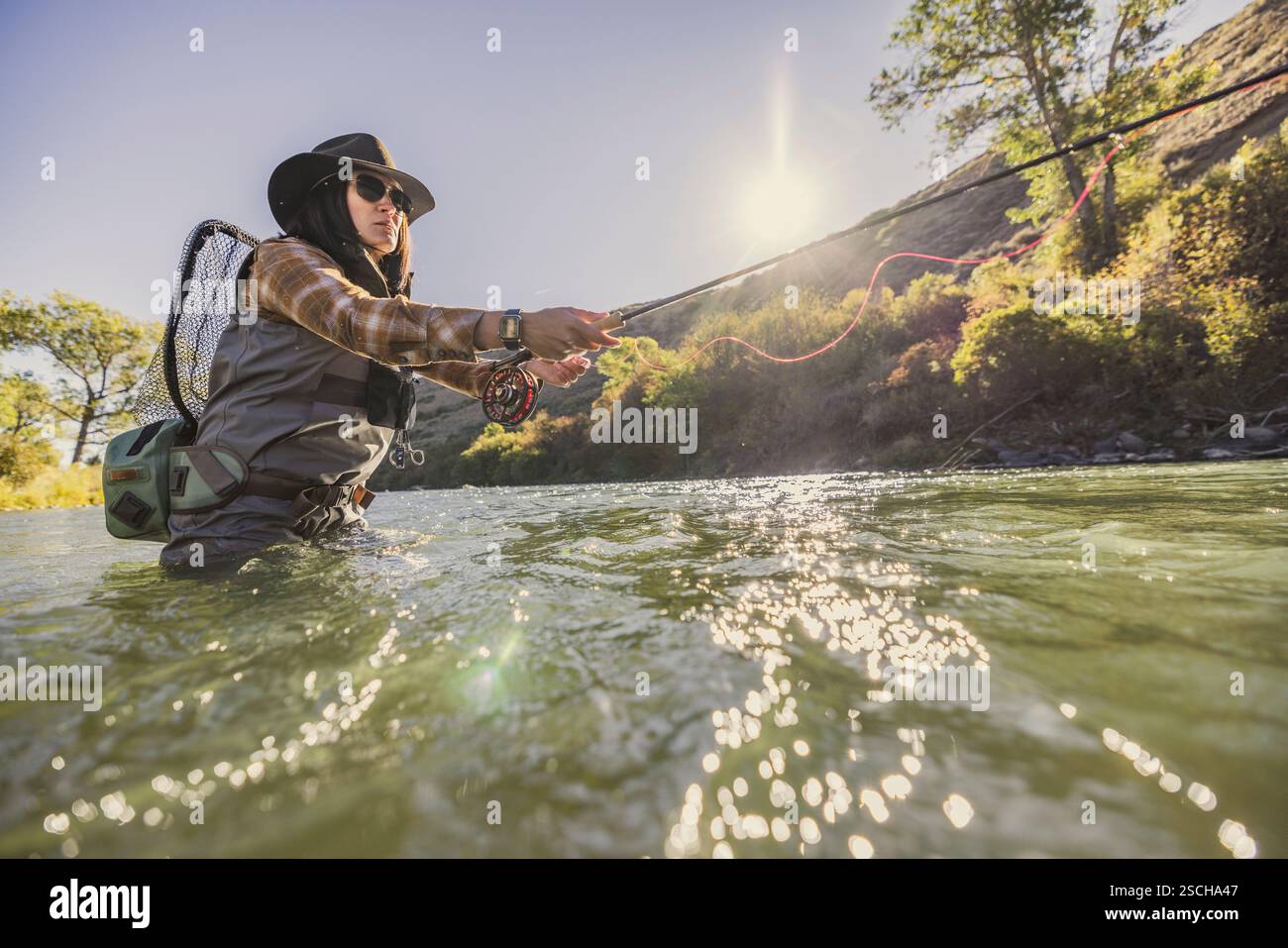 Fly fishing woman adjust her fly line Stock Photo - Alamy