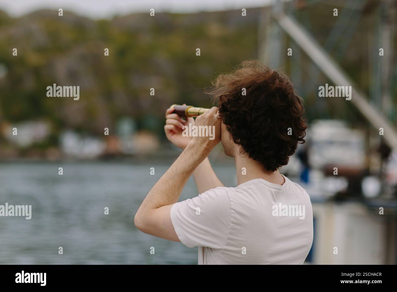 Back view of an unrecognizable man using a telescope to explore the ...
