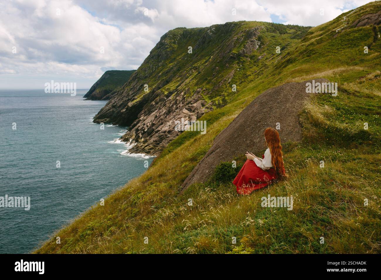 Woman reading book on cliff hi-res stock photography and images - Alamy