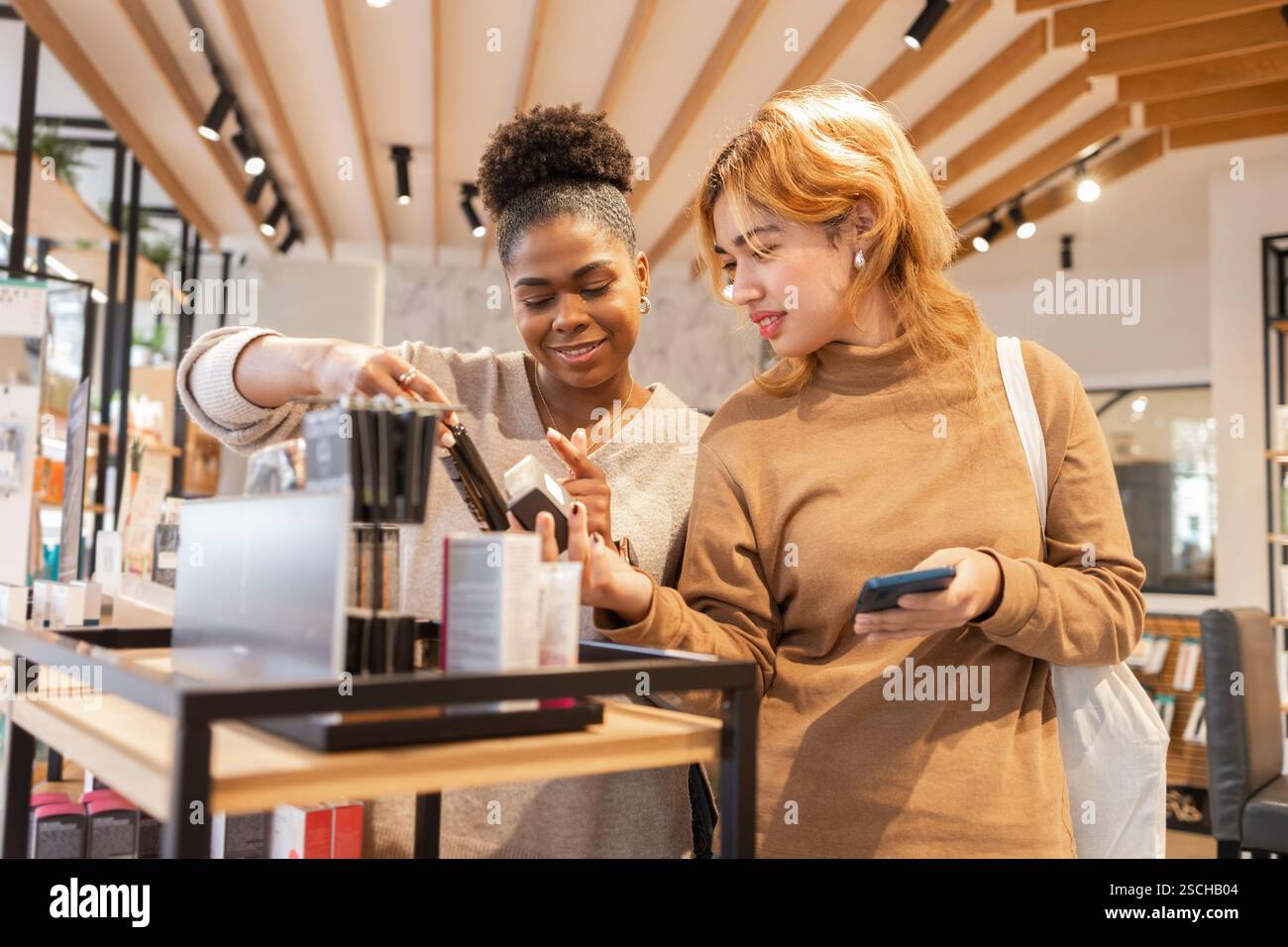 Two women in a bright cosmetics store share a friendly interaction ...