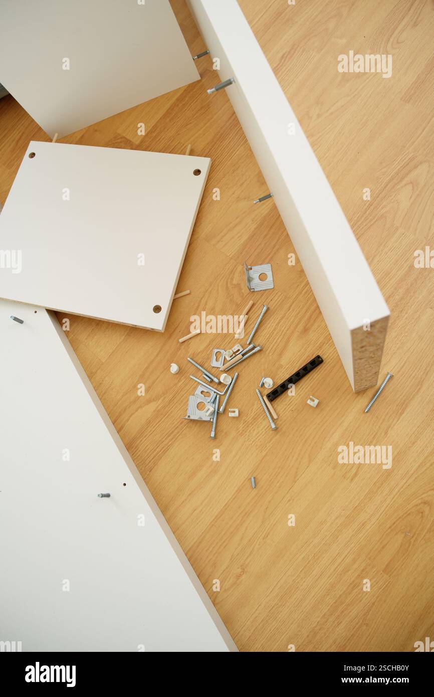 Assembling new furniture, showcasing scattered hardware and assembly ...