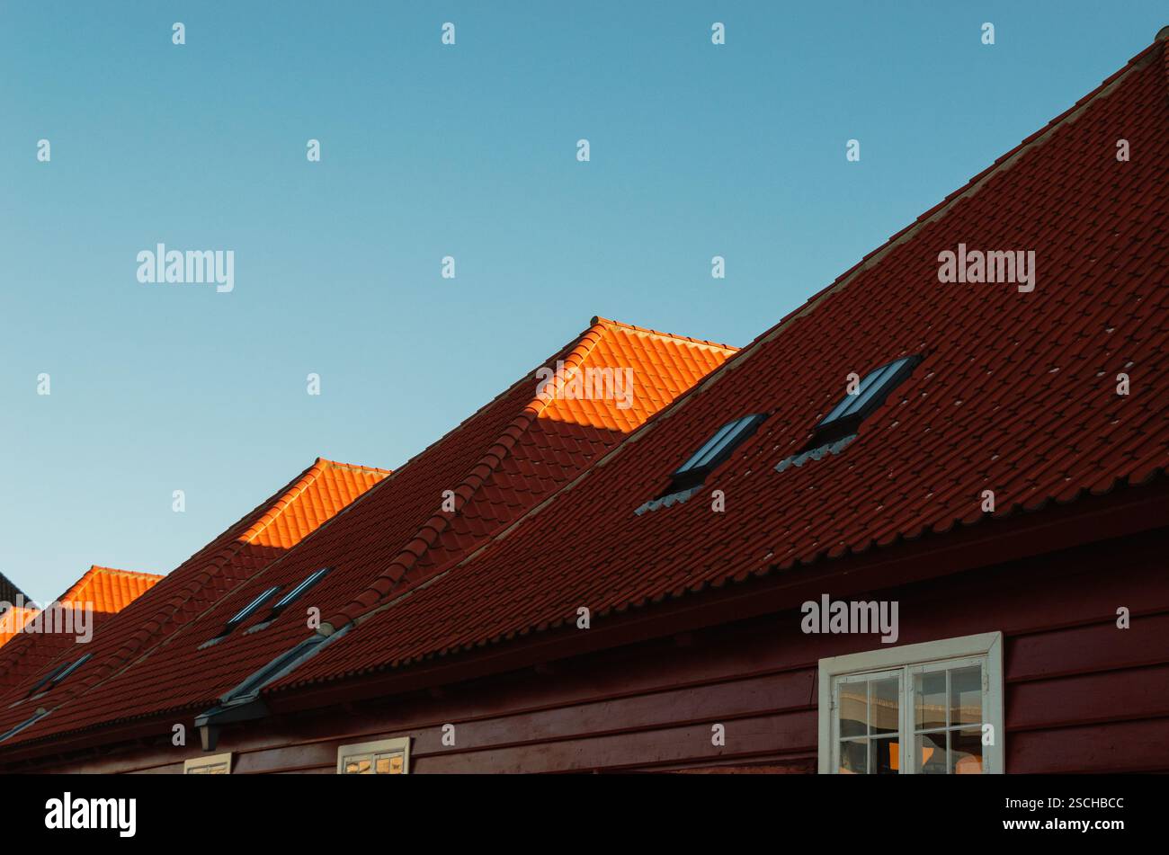 peaked orange roof shingles against blue sky Stock Photo - Alamy