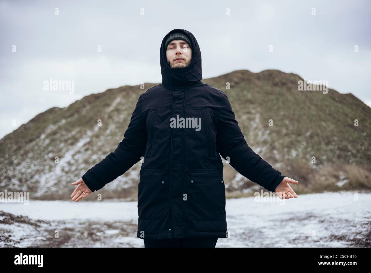 A man stands with his eyes closed, arms outstretched, enjoying the ...