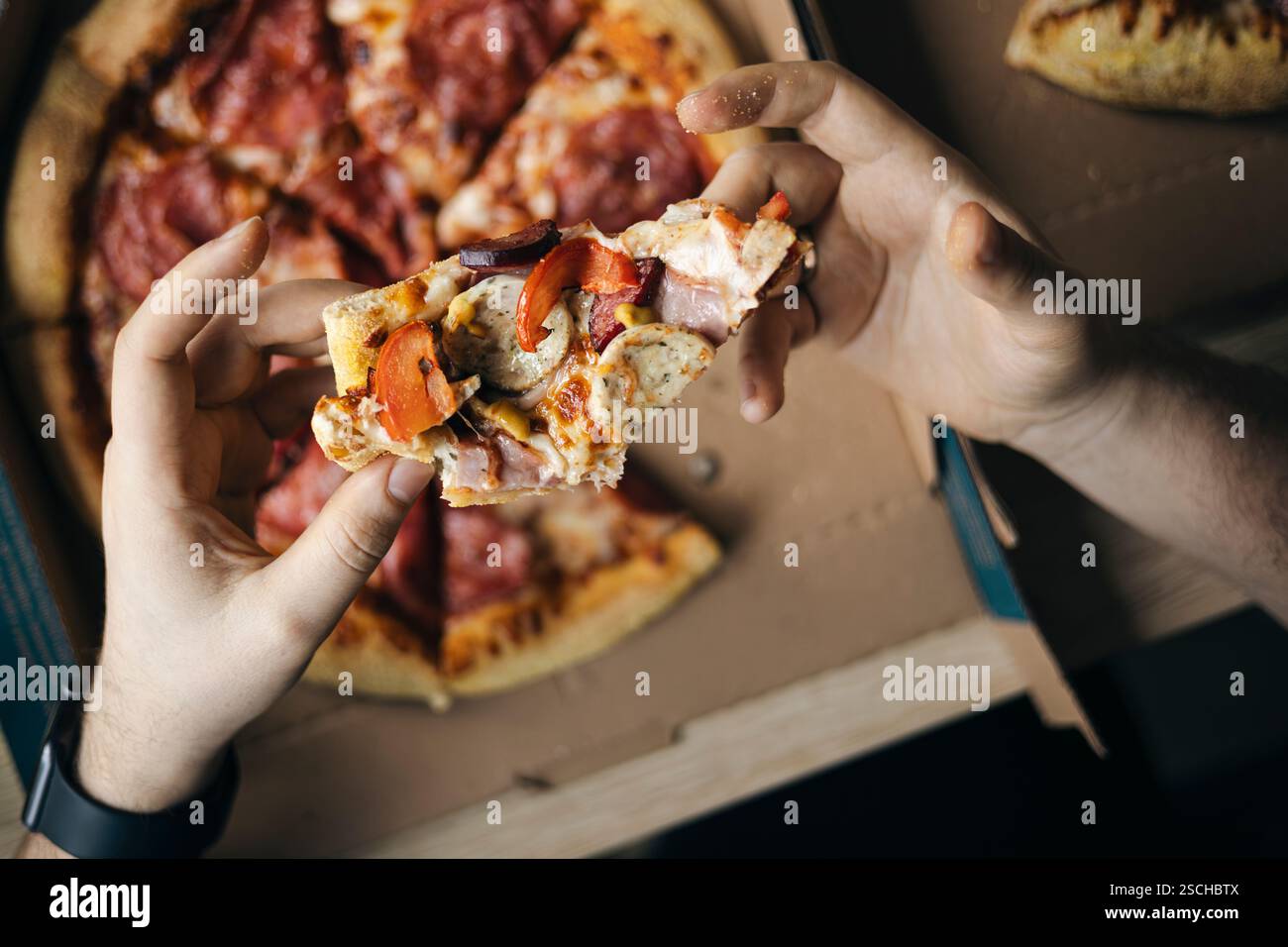 From above cropped unrecognizable hands holding slices of a delicious ...