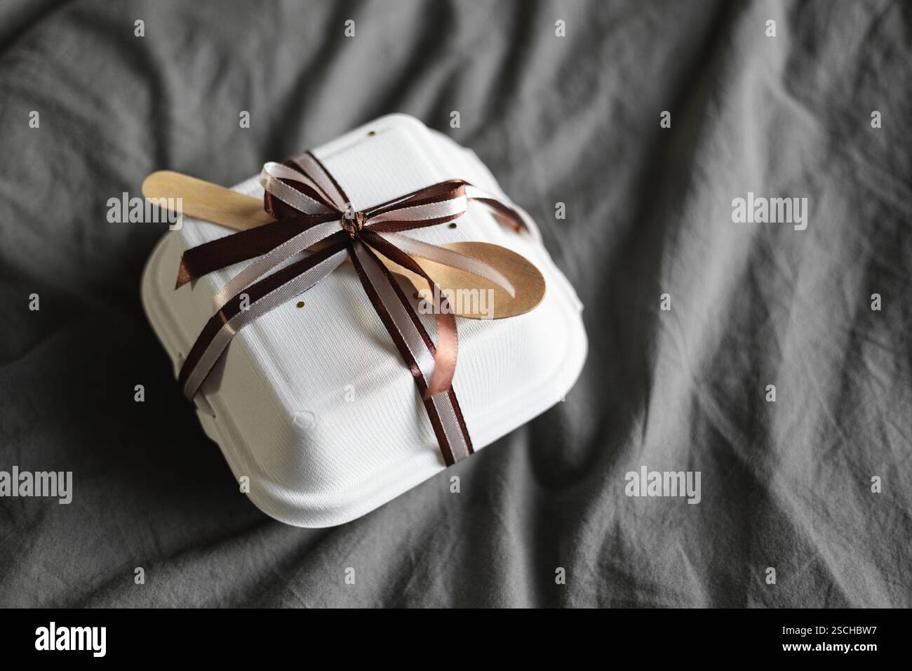 Top view of a bento birthday cake elegantly wrapped and secured with ...
