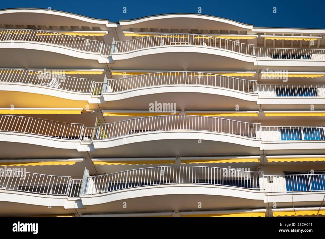A view of modern apartment balconies featuring a distinct curved design ...