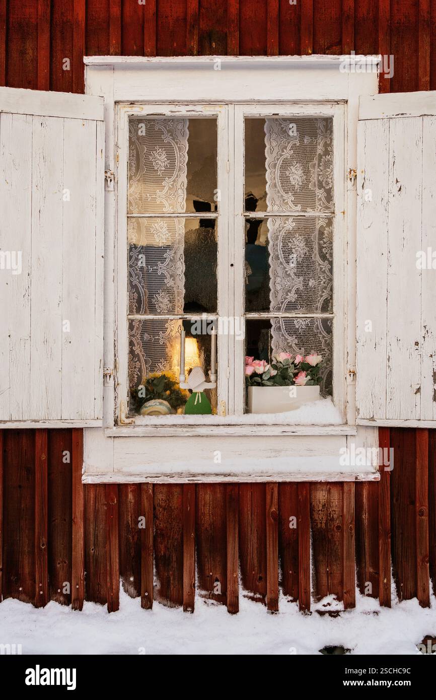 A charming winter scene in Swedish Lapland features a rustic window ...