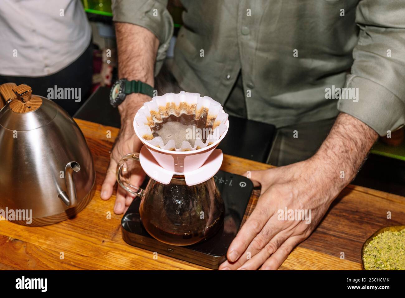 A barista skillfully prepares specialty coffee using a pour-over method ...
