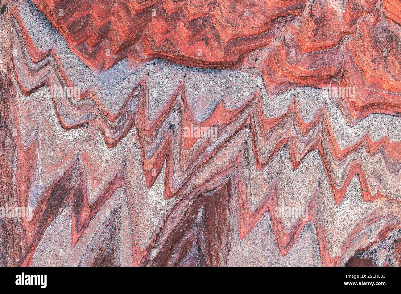 This aerial image captures the intricate, colorful patterns of a rugged ...