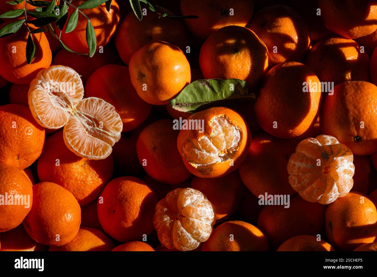 A collection of vibrant tangerines with some peeled, showcasing their ...