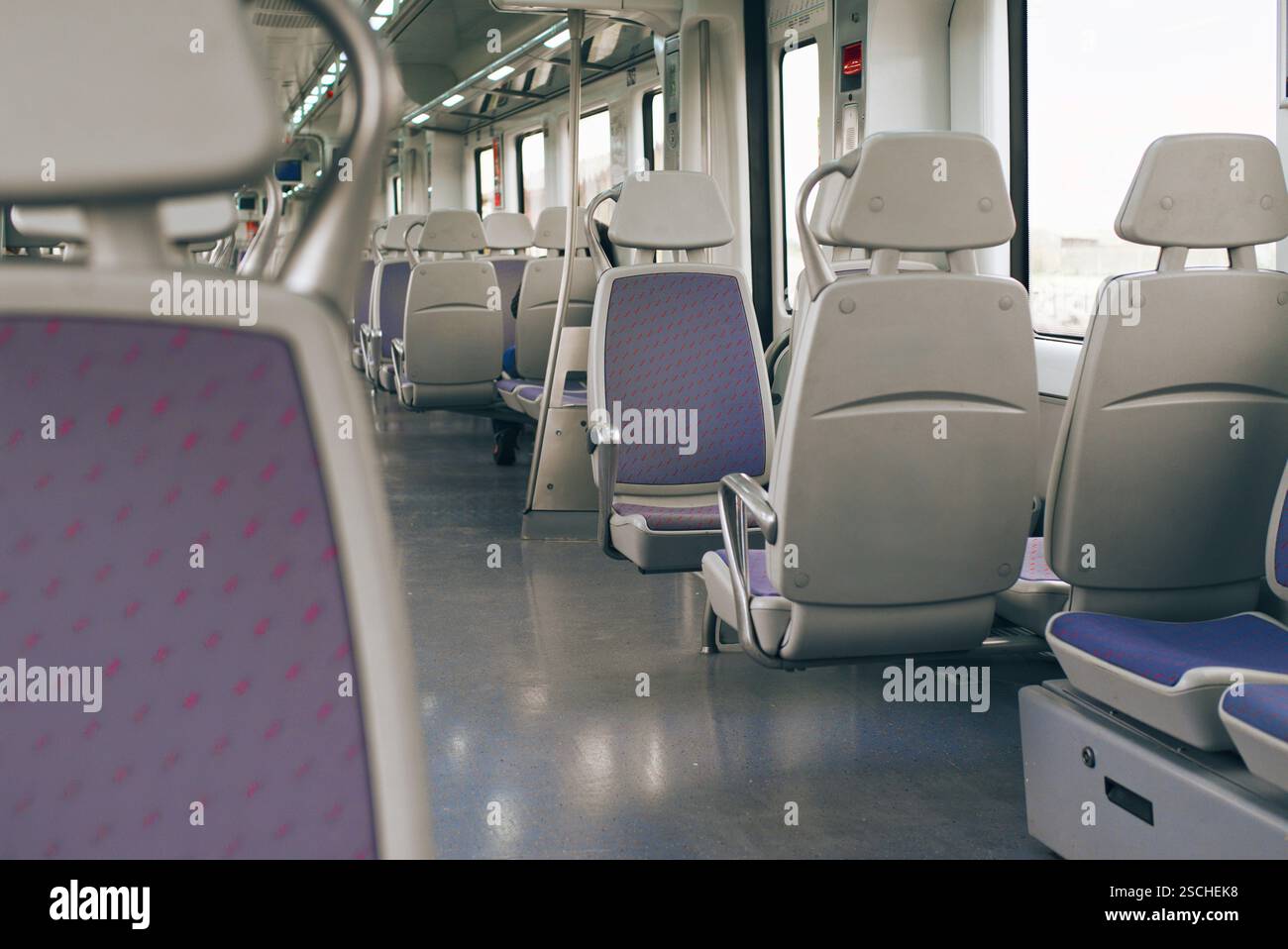 A spacious and well lit interior of a modern train, featuring rows of ...